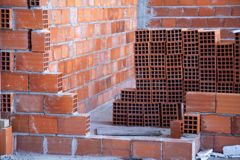 A Newly Built Brick Wall Stands Sturdy, with a Stack of Unused Bricks ...