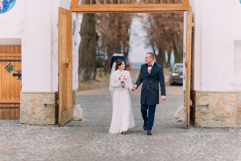Newlywed Pair Walk through the Gateway Holding Hands Together Stock ...