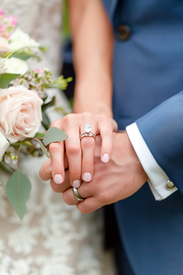 Newlyweds Holding Hands, Showcasing a Sparkling Engagement Ring ...