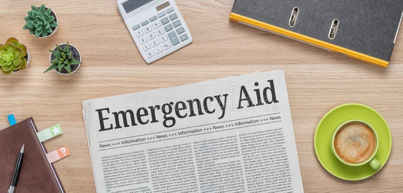 A Newspaper on a Desk with the Headline Emergency Aid Stock Photo ...