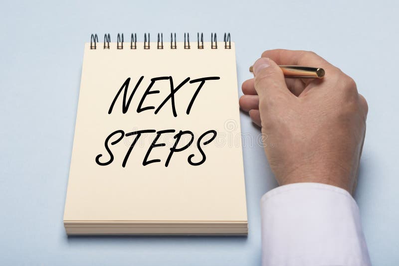 Next Step Phrase on Yellow Notebook on Blue Table with Male Hand Stock ...