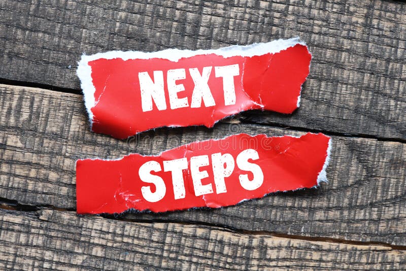 NEXT STEPS Words on Small Red Sheets of Paper Laid on a Wooden Table ...