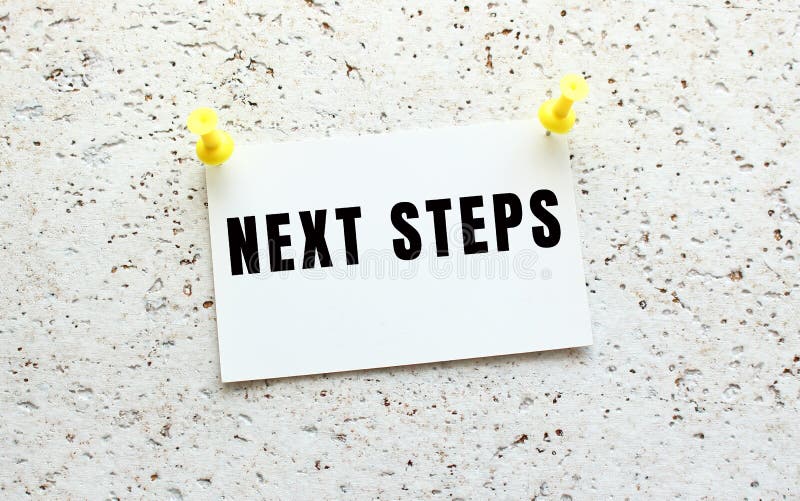 NEXT STEPS Lettering on a Yellow Sheet of Paper Over Crumpled Kraft ...