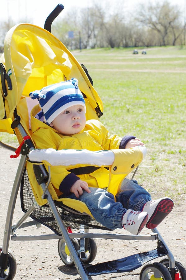 Nice Baby Outdoors on Yellow Buggy in Spring Stock Photo - Image of ...