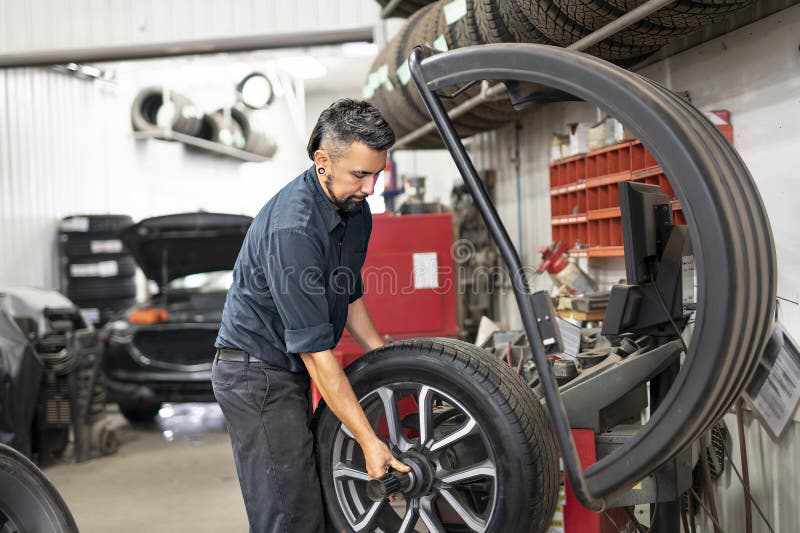 Nice and Cool Mechanic Changing Car Tire at Work Stock Image - Image of ...