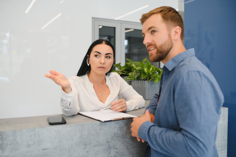 Nice Friendly Woman Talking To the Client while Standing at the ...