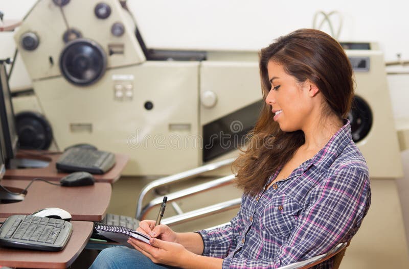 Nice Girl Working with a Computer and Writting on Her Notebook Stock ...