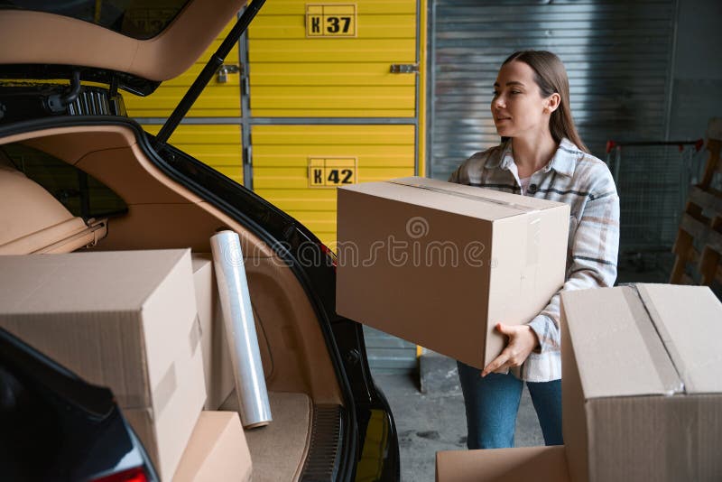 Nice Grown Woman Loading a Box into the Trunk Stock Photo - Image of ...