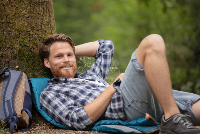 Man sitting against tree stock photo. Image of relaxed - 21963692