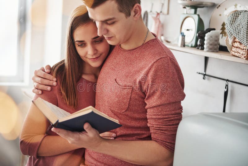 Nice People. Cute Couple Reading Book Together at Home in the Kitchen ...