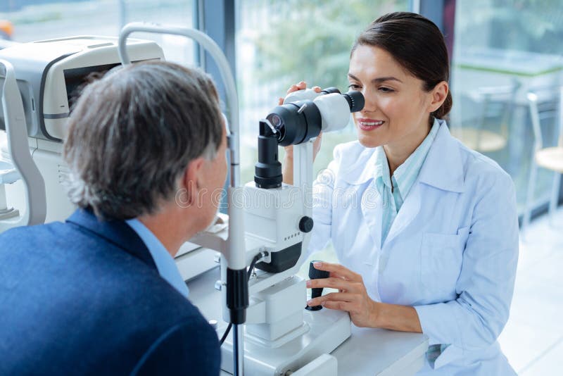 Nice Positive Optician Looking into the Microscope Stock Photo - Image ...