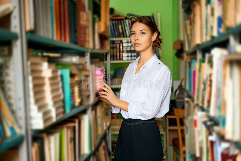 A Nice Woman in a White Shirt in the Library is Smiling Stock Photo ...