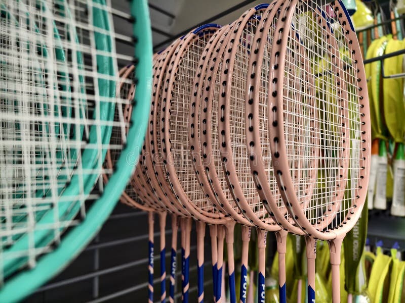 A Nicely Organized Row of Badminton Rackets Hanging on a Rack in a ...