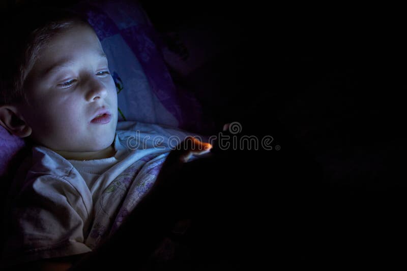 At Night the Boy Plays Games in Bed,in the Bedroom at Night the Boy ...