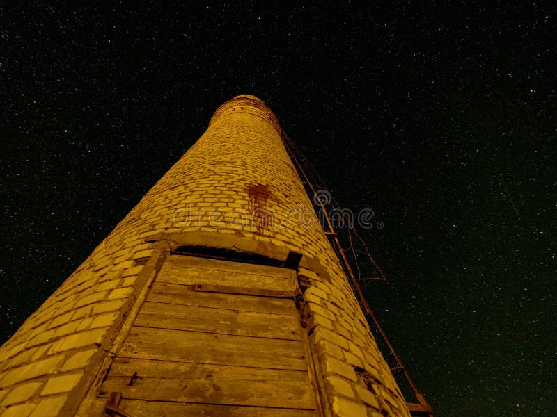Night Landscape with an Illuminated Brick Tower Against the Night Sky ...