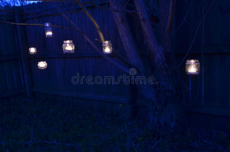 Night Scene Candles in Jars Hanging on Tree Branches Stock Image ...