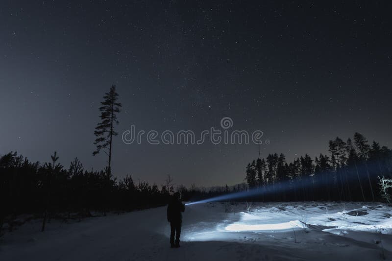 Night Scene, a Man with a Flashlight in the Forest Road in Winter ...