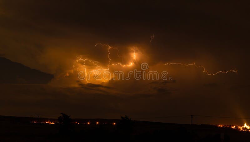 Night Sky with Lightning Illuminating Clouds Over Distant Landscape ...