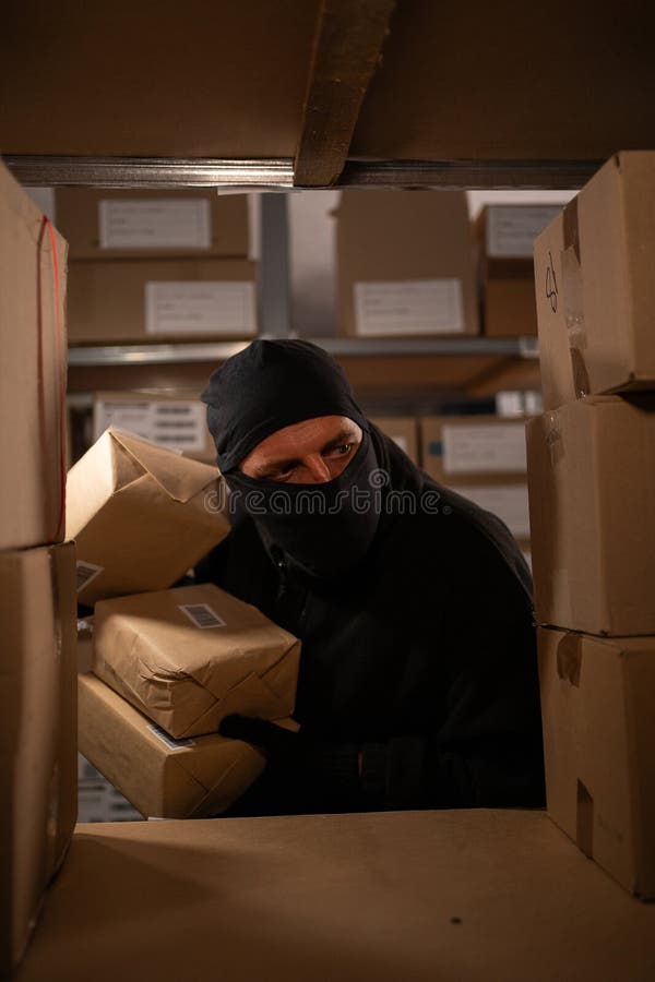 Thief Wears Gloves Steal Boxes of Goods in a Warehouse in the Dark ...