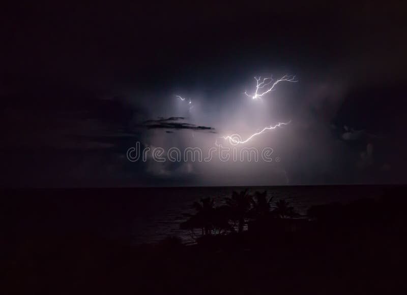 Night View of an Ocean Under the Mesmerizing Purple Sky with Lightning ...