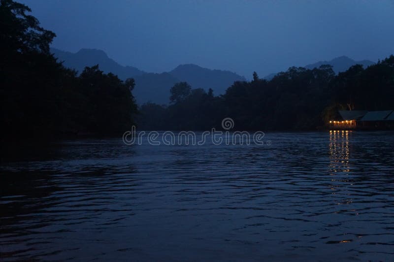 Night View of a Peaceful Lake Surrounded by a Forest with a Lighted ...