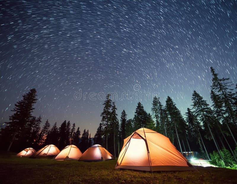 Nighttime Camping in the Forest with Lit Tents and Starry Sky Stock ...