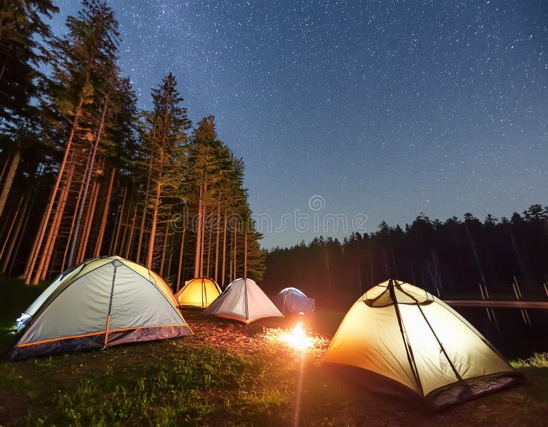 Nighttime Camping in the Forest with Lit Tents and Starry Sky Stock ...