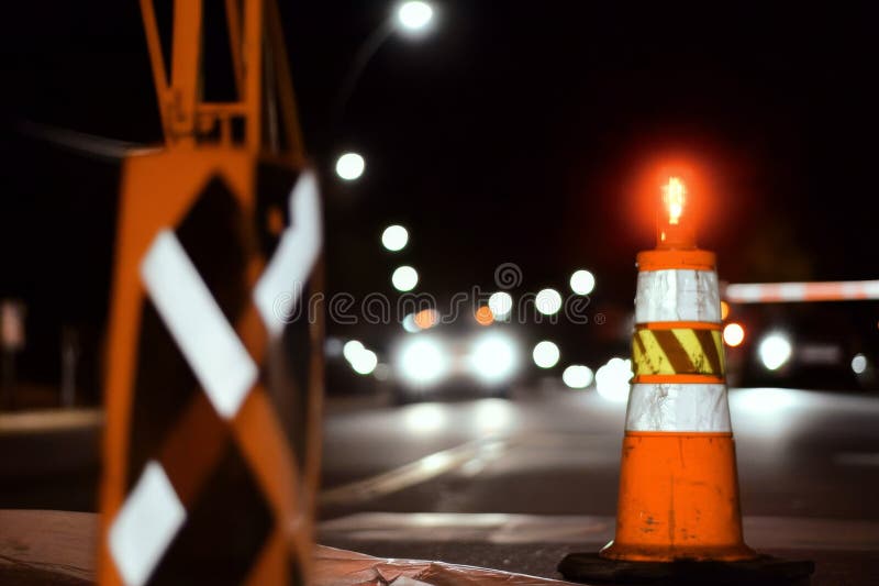 Nighttime Road Construction Scene with Traffic Cone and Blurred Lights ...