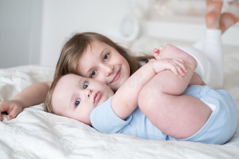 Niña Hermana Mayor Besando a Su Hermanito Bebé Niño En La Cama En Casa ... Niña Hermana Mayor Besando a Su Hermanito Bebé Niño En La Cama En Casa ...