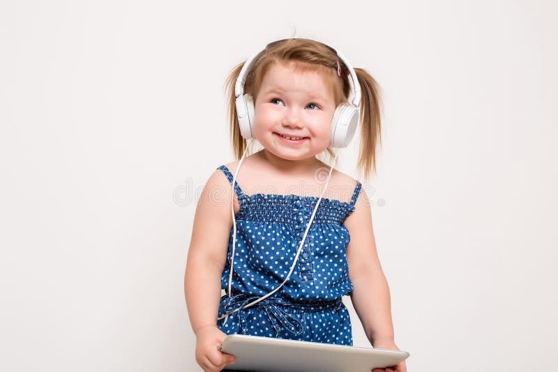 Niña Linda En Auriculares Que Escucha La Música Usando Una Tableta Y