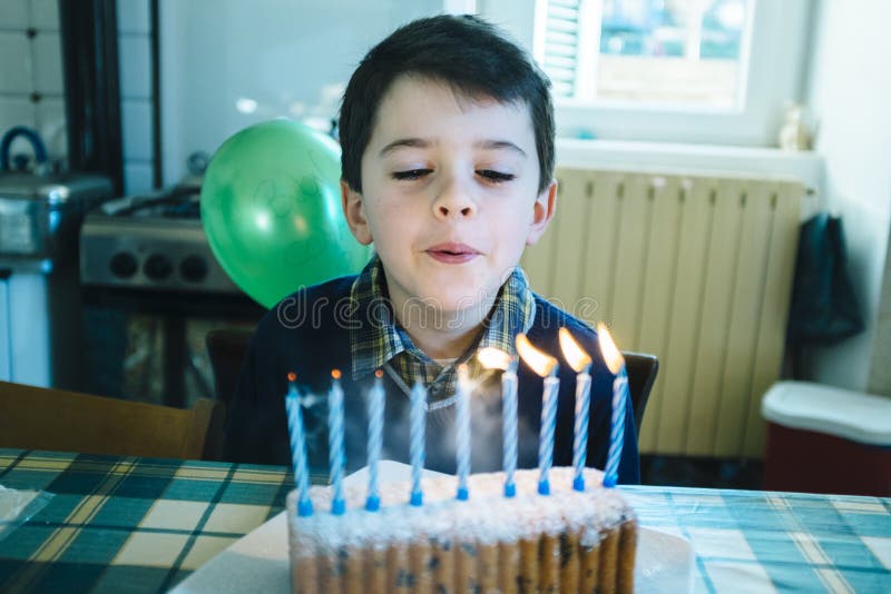 Niño En El Día De Su Noveno Cumpleaños Que Sopla Las Velas En El Th ... Niño En El Día De Su Noveno Cumpleaños Que Sopla Las Velas En El Th ...