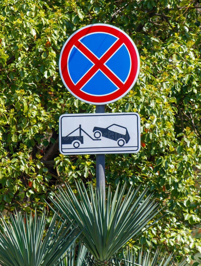 A No Parking Sign is on a Pole Next To a No Towing Sign Stock Image ...