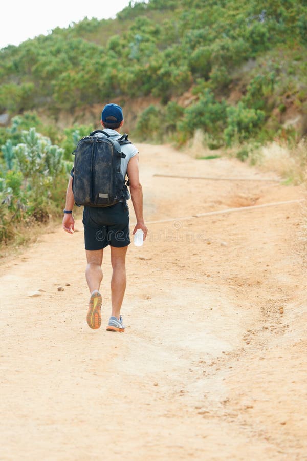 No Trail Left Unexplored. Rear-view of a Hiker Walking Down a Dirt Road ...
