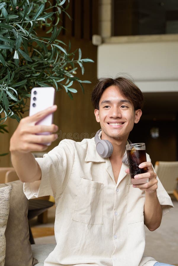 Non Binary Asian Student Man Sitting in Modern Coffee Shop Drinking ...