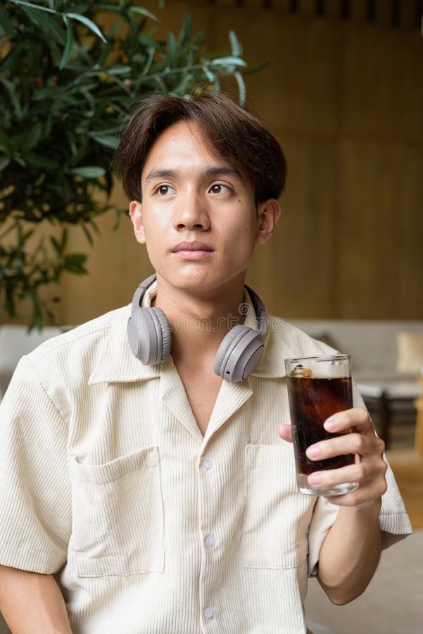 Non Binary Asian Student Man Sitting in Modern Coffee Shop Drinking ...