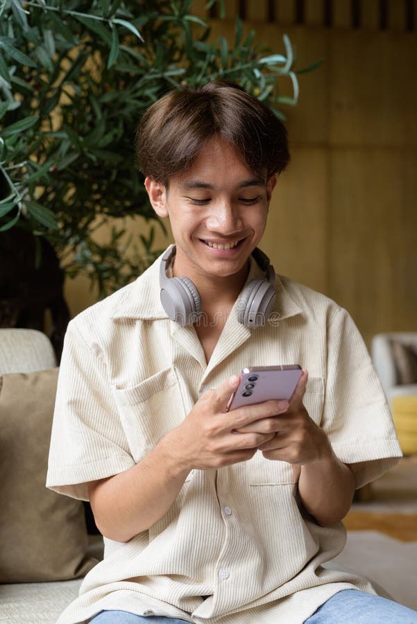 Non Binary Asian Student Man Sitting in Modern Coffee Shop Texting with Phone Stock Photo ...