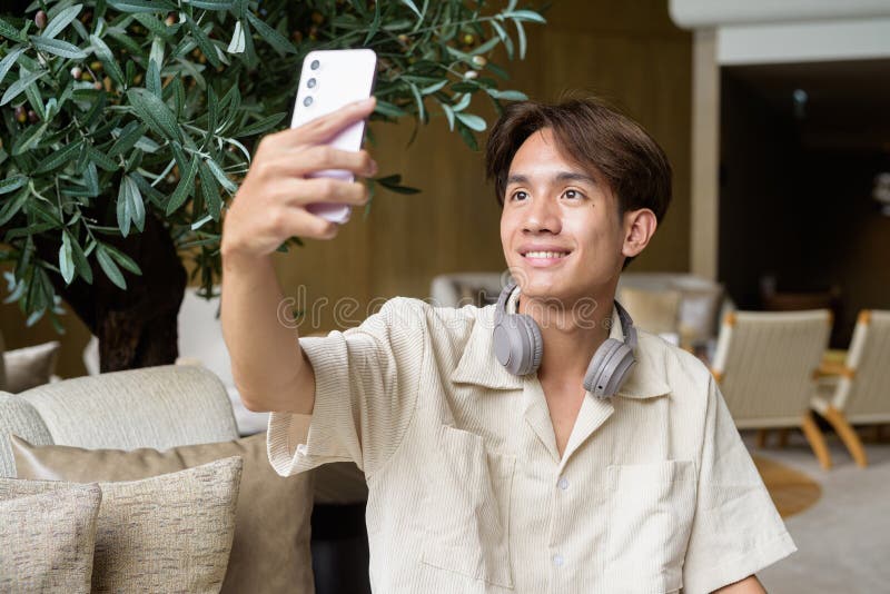 Non Binary Asian Student Man Sitting in Modern Coffee Shop Using Phone ...