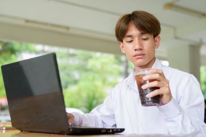 Non Binary University Student in College Campus Using Laptop Computer ...