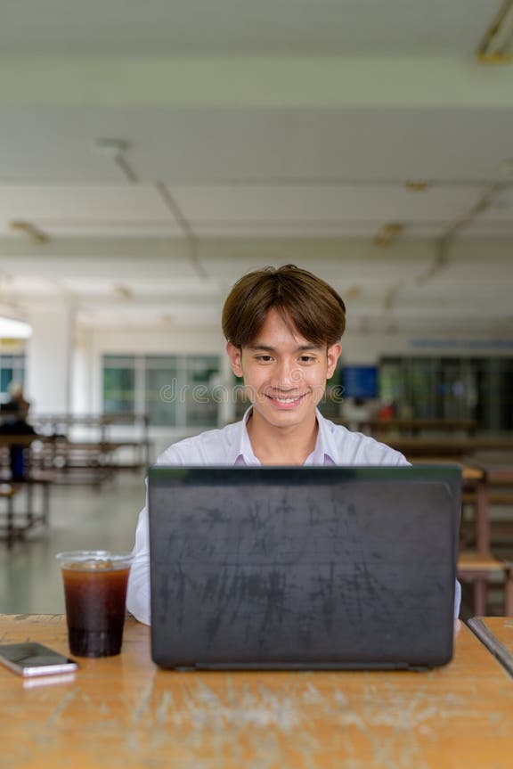 Non Binary University Student Sitting in College Campus Using Laptop Computer Stock Photo ...
