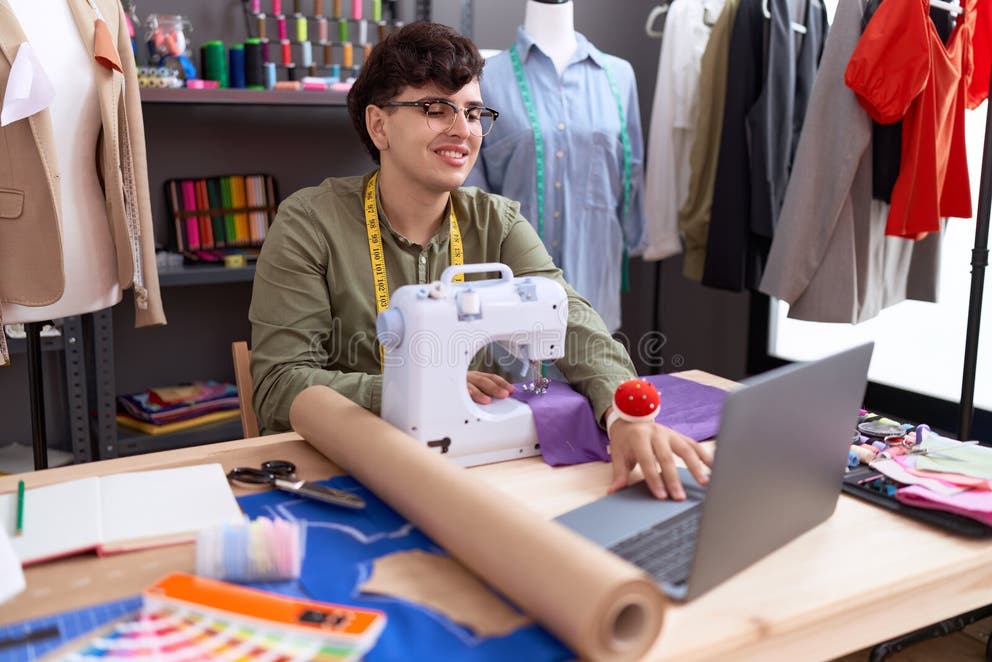 Non Binary Man Tailor Using Sewing Machine and Laptop at Atelier Stock ...