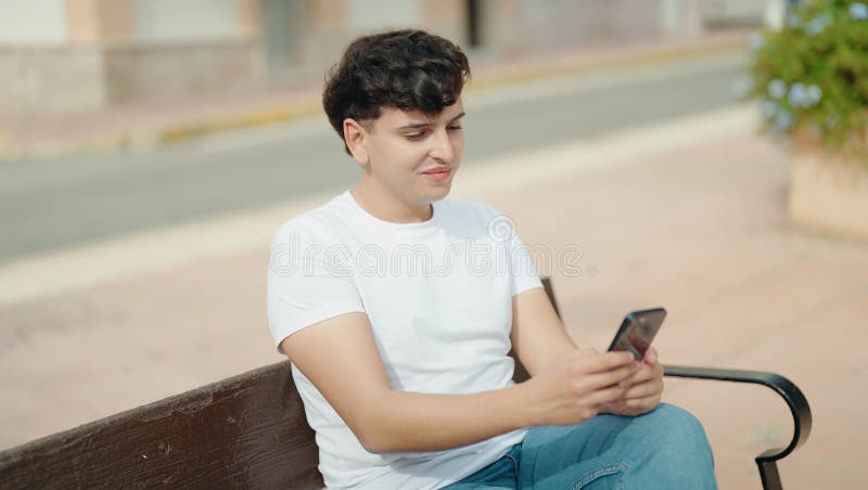 Non Binary Man Using Smartphone Sitting on Bench at Park Stock Photo ...