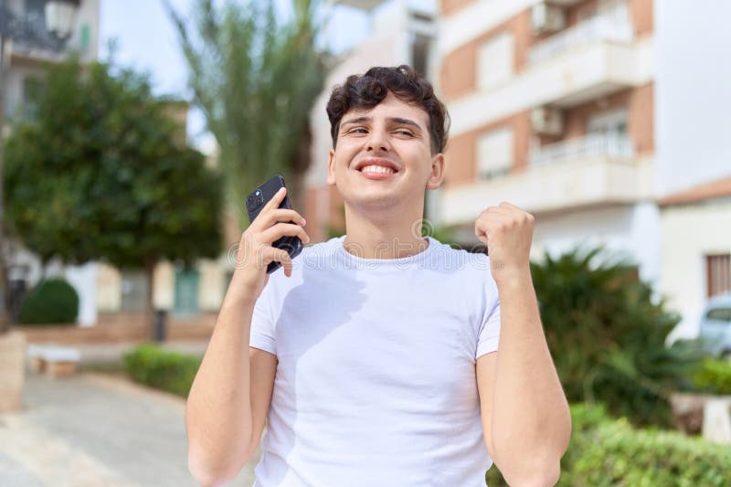 Non Binary Man Using Smartphone with Winner Expression at Park Stock ...