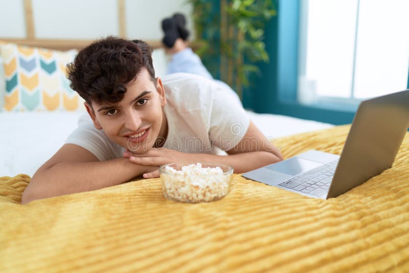 Non Binary Man Watching Movie on Laptop Lying on Bed at Bedroom Stock ...