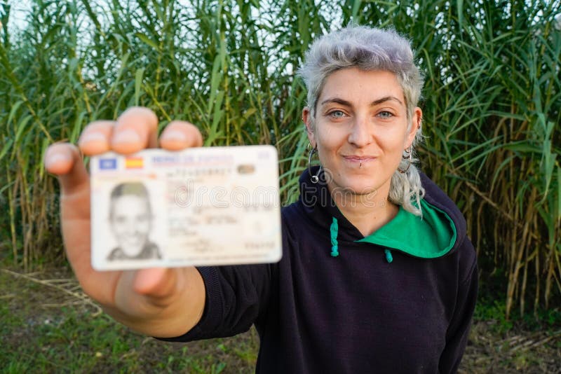 Non-binary Person Looking at Camera with ID in Hand. Non-binary ... Non-binary Person Looking at Camera with ID in Hand. Non-binary ...