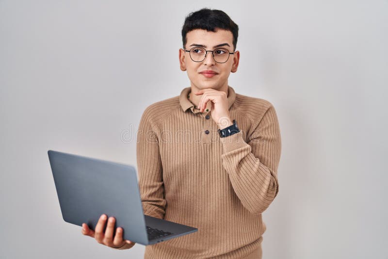 Non Binary Person Using Computer Laptop with Hand on Chin Thinking ...