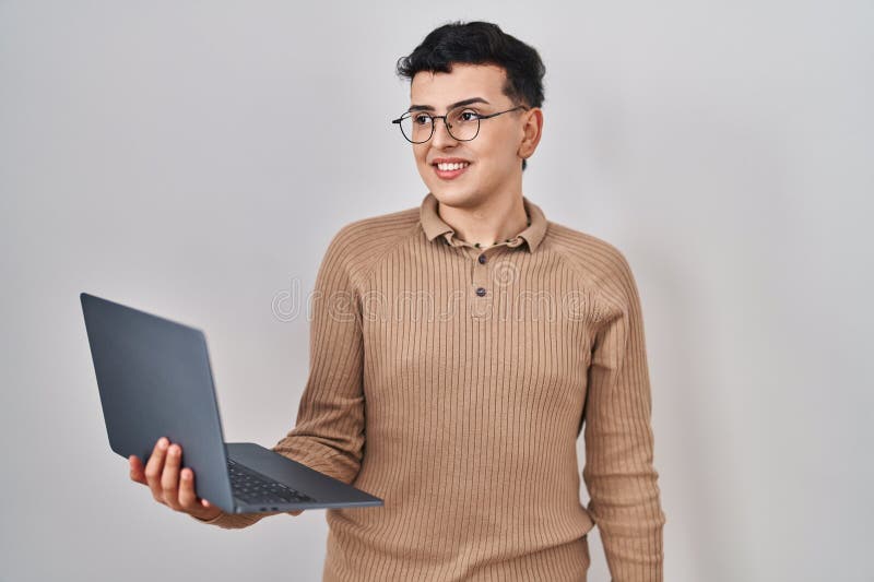 Non Binary Person Using Computer Laptop Looking Away To Side with Smile ...