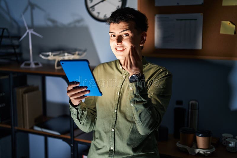 Non Binary Person Using Touchpad Device at Night Doing Money Gesture ...