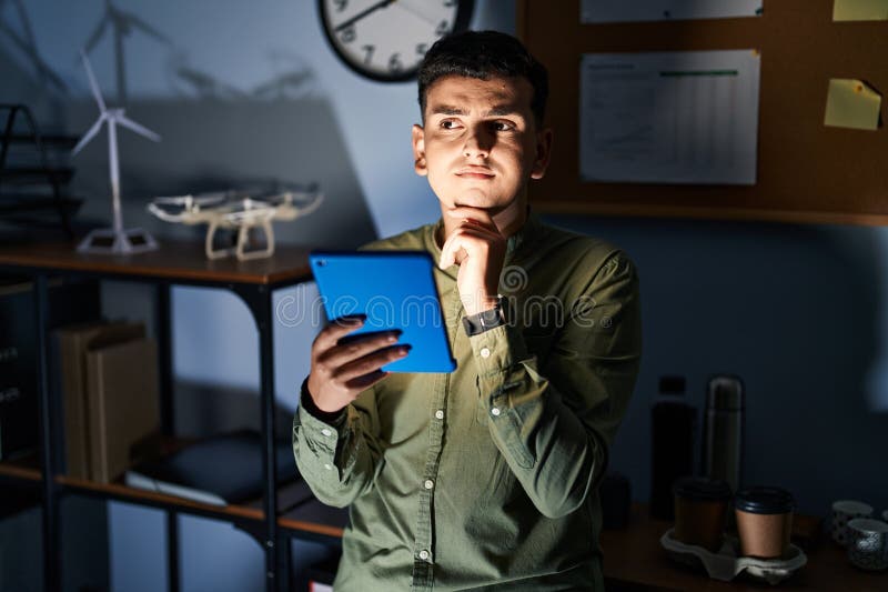 Non Binary Person Using Touchpad Device at Night Thinking Concentrated ...