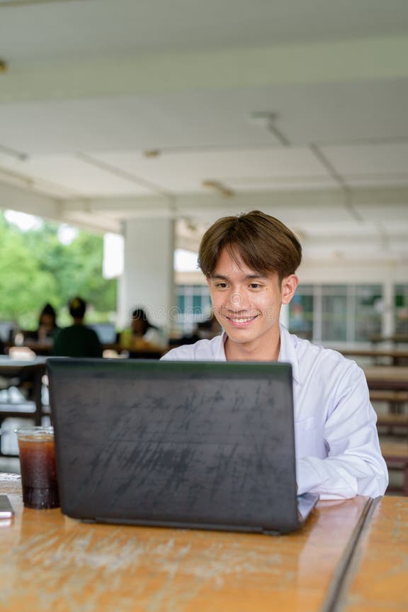 Non Binary University Student Sitting in College Campus Using Laptop Computer Stock Photo ...