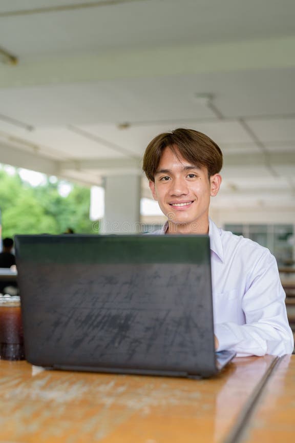Non Binary University Student Sitting in College Campus Using Laptop Computer Stock Photo ...